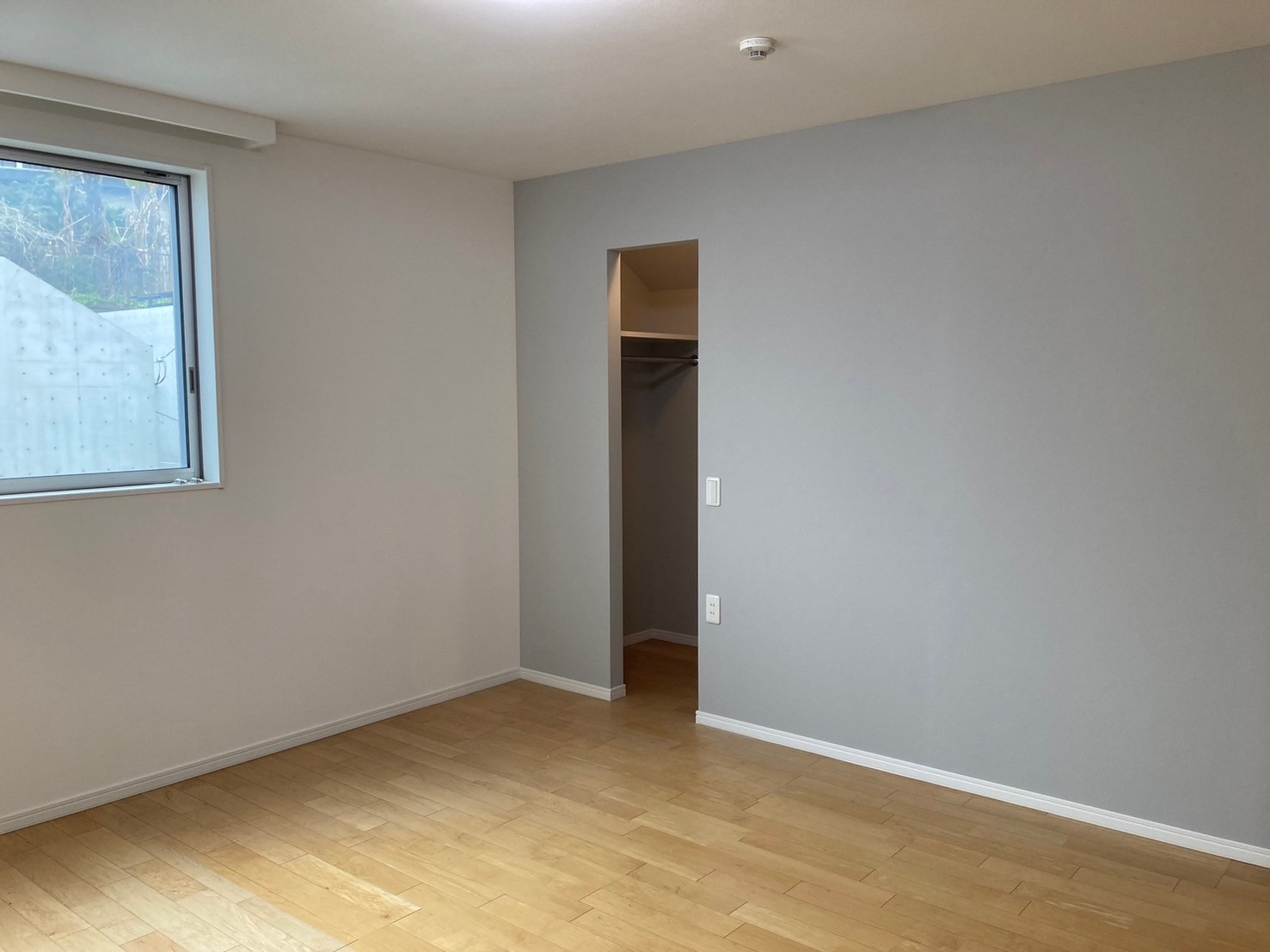 クールグレーのアクセントクロスが都会的で洗練された印象の洋室へ｜東京都大田区のG様邸にて収納リフォーム - 大田区でマンション・アパートのリフォームするなら「アーバンサービス」